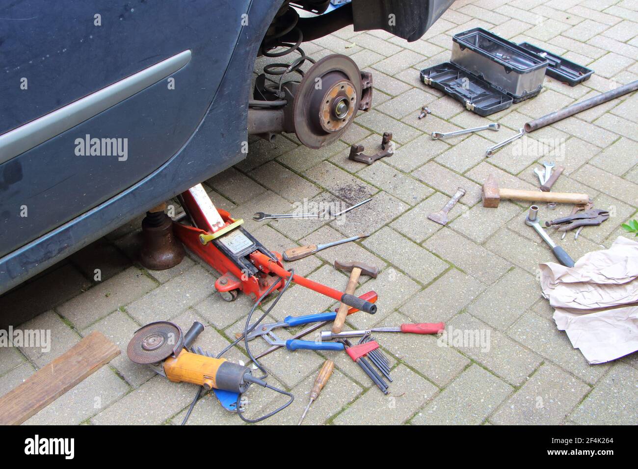 Car under repair on jack and tools on the ground Stock Photo - Alamy