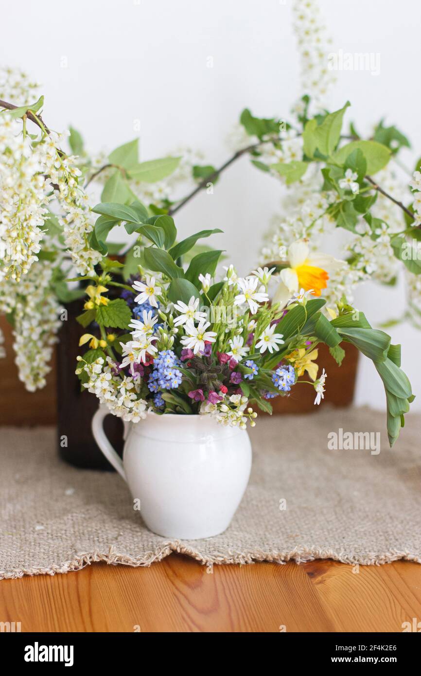 Beautiful spring wildflowers on rustic wooden table. Spring rural still ...