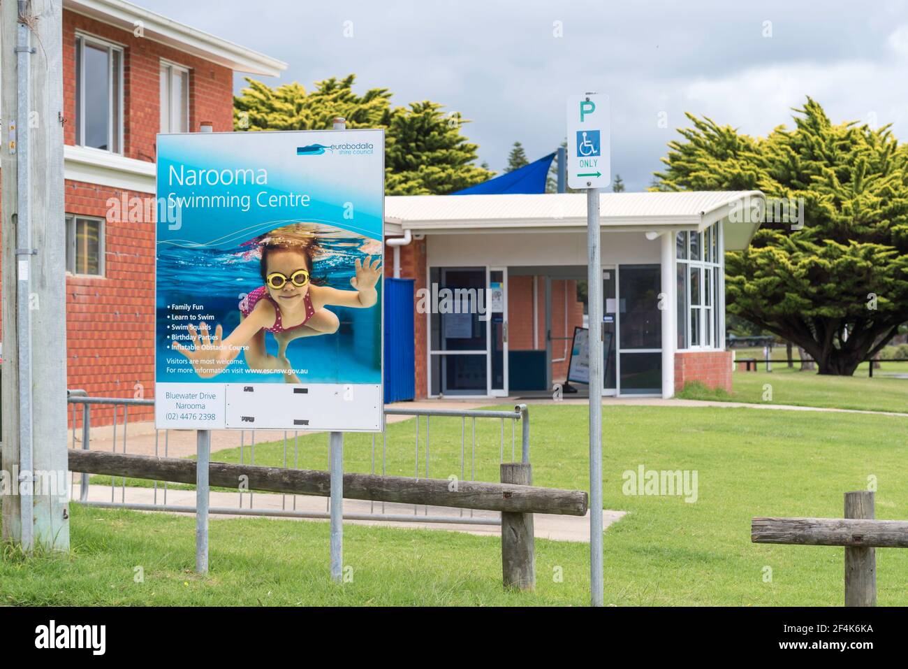A sign outside and the entrance to the public swimming pool at Narooma ...