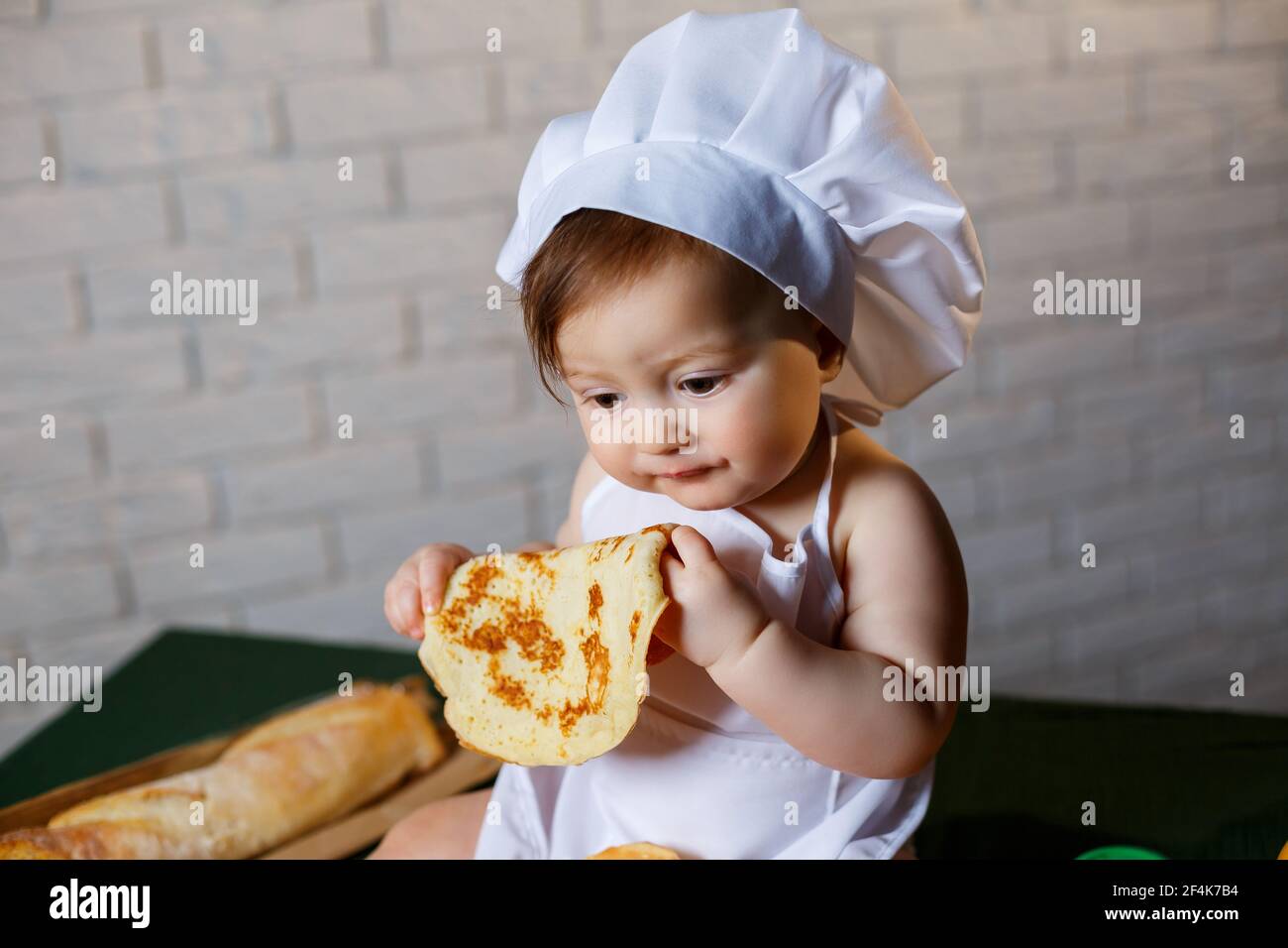 Little chef. Little kid dressed as a chef with pastries, buns, bread ...