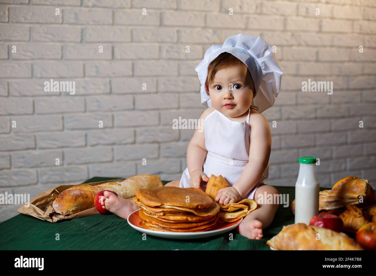 Little chef. Little kid dressed as a chef with pastries, buns, bread ...
