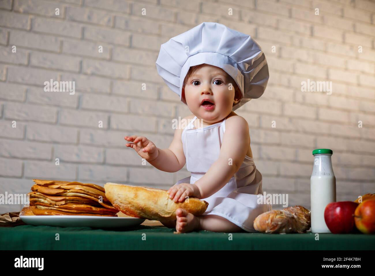 Little chef. Little kid dressed as a chef with pastries, buns, bread ...