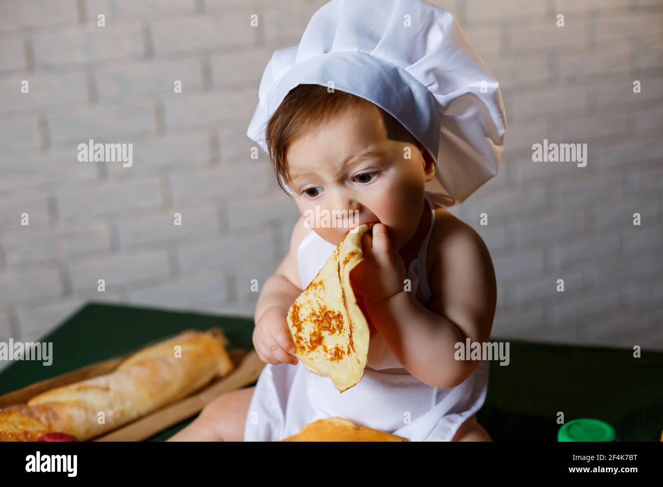 Little chef. Little kid dressed as a chef with pastries, buns, bread ...