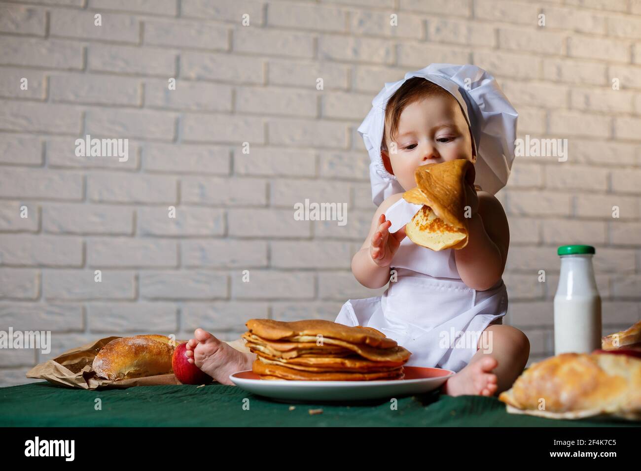 Little chef. Little kid dressed as a chef with pastries, buns, bread ...