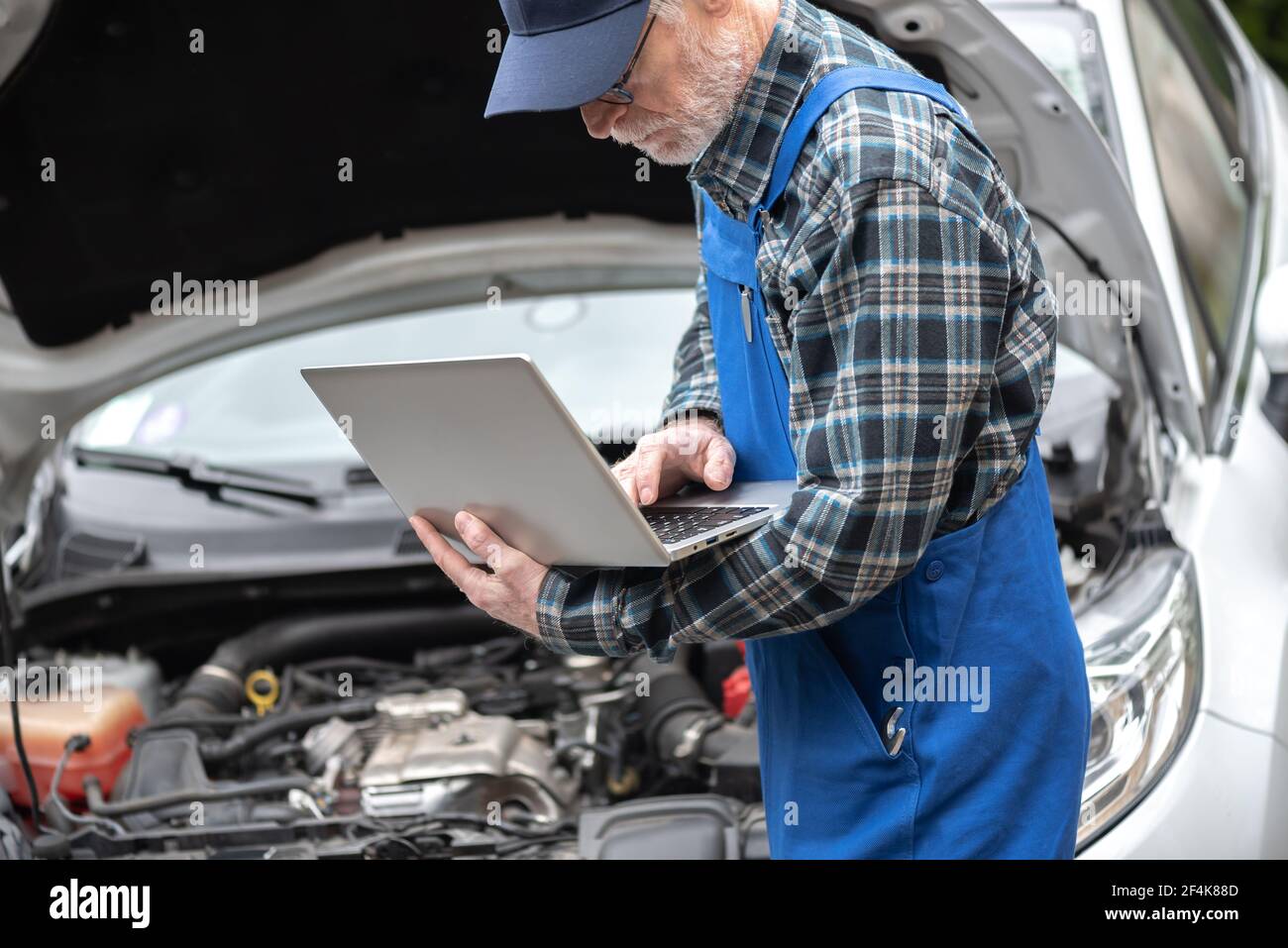 Car mechanic using laptop for checking car engine Stock Photo - Alamy