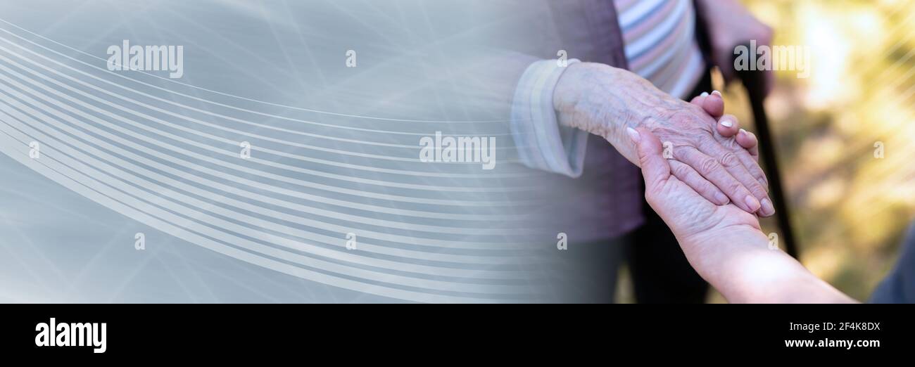 Concept of elderly support; young and aged holding hands; panoramic ...