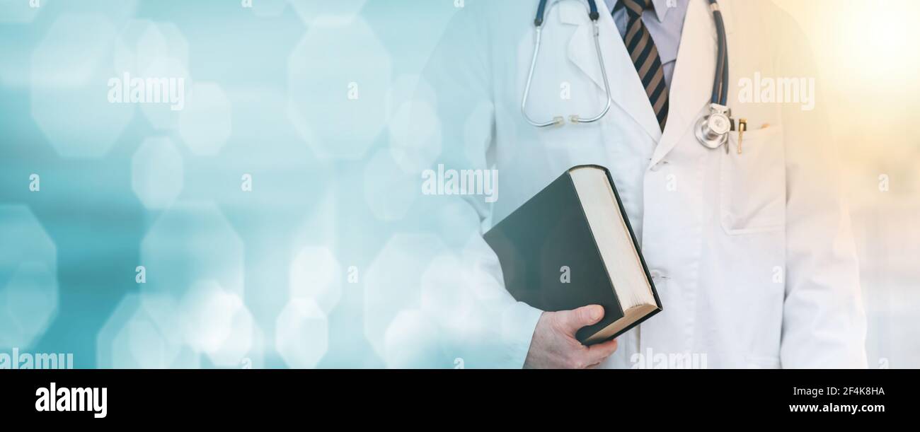 Doctor standing and holding a medical textbook; light effect Stock ...