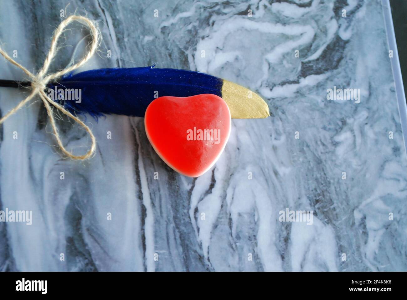 Heart shape red jelly with colorful feather isolated on beautiful ...