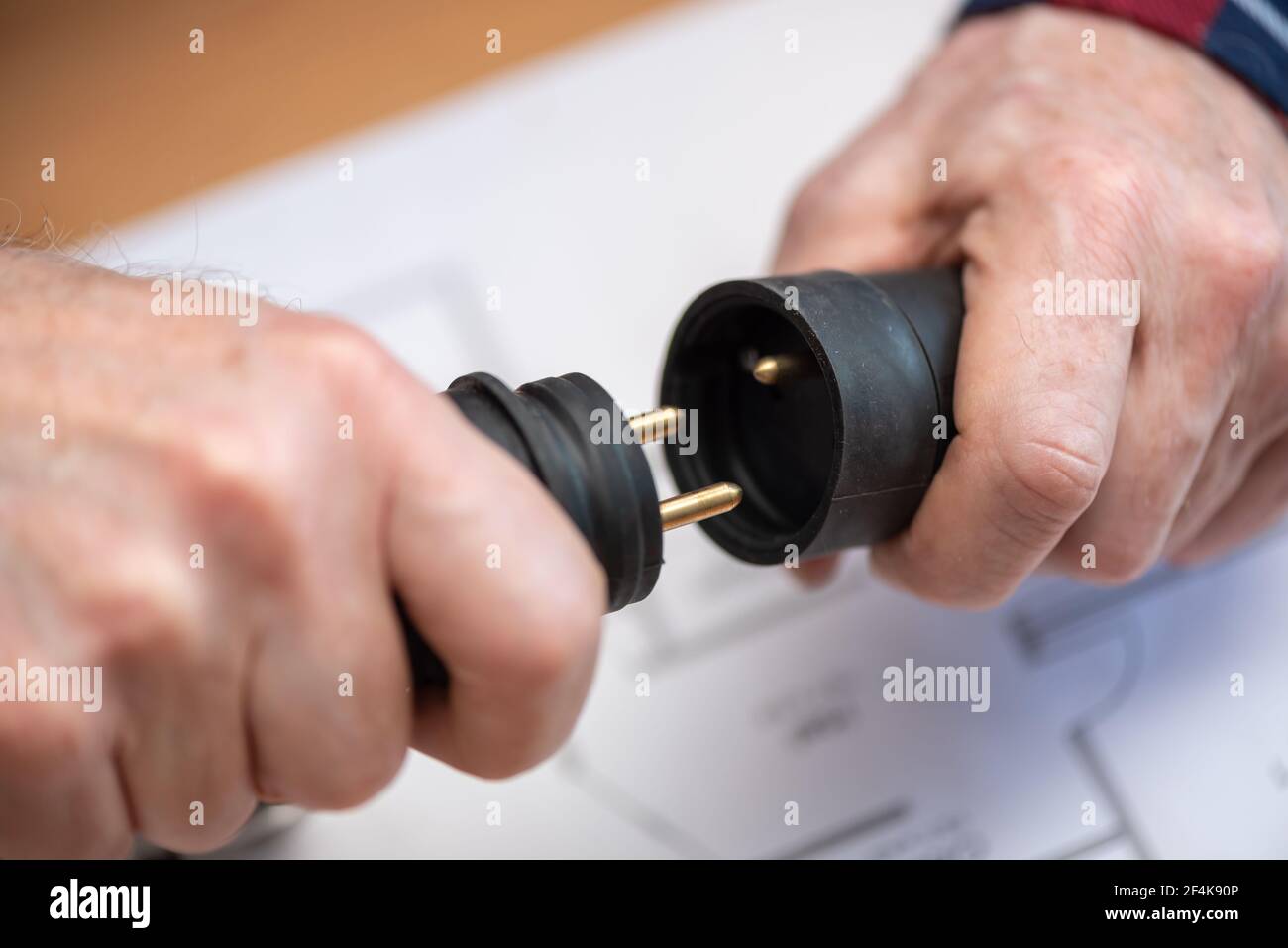 Electrician hands holding electrical plugs Stock Photo - Alamy