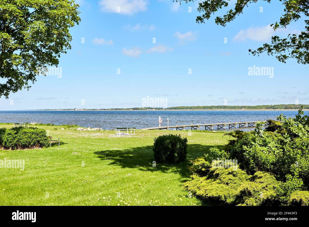 a green field by the water on hot summer day Stock Photo - Alamy