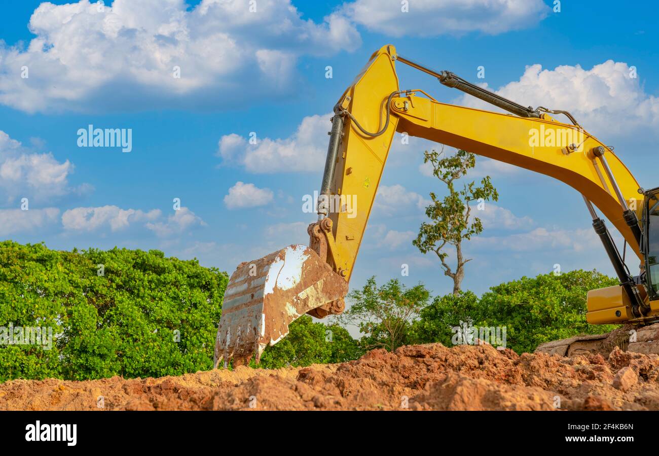 Backhoe working by digging soil at construction site. Bucket of backhoe ...