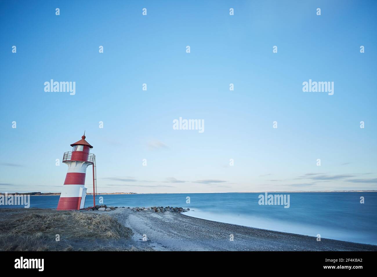 a red and white lighthouse on the beach Stock Photo - Alamy