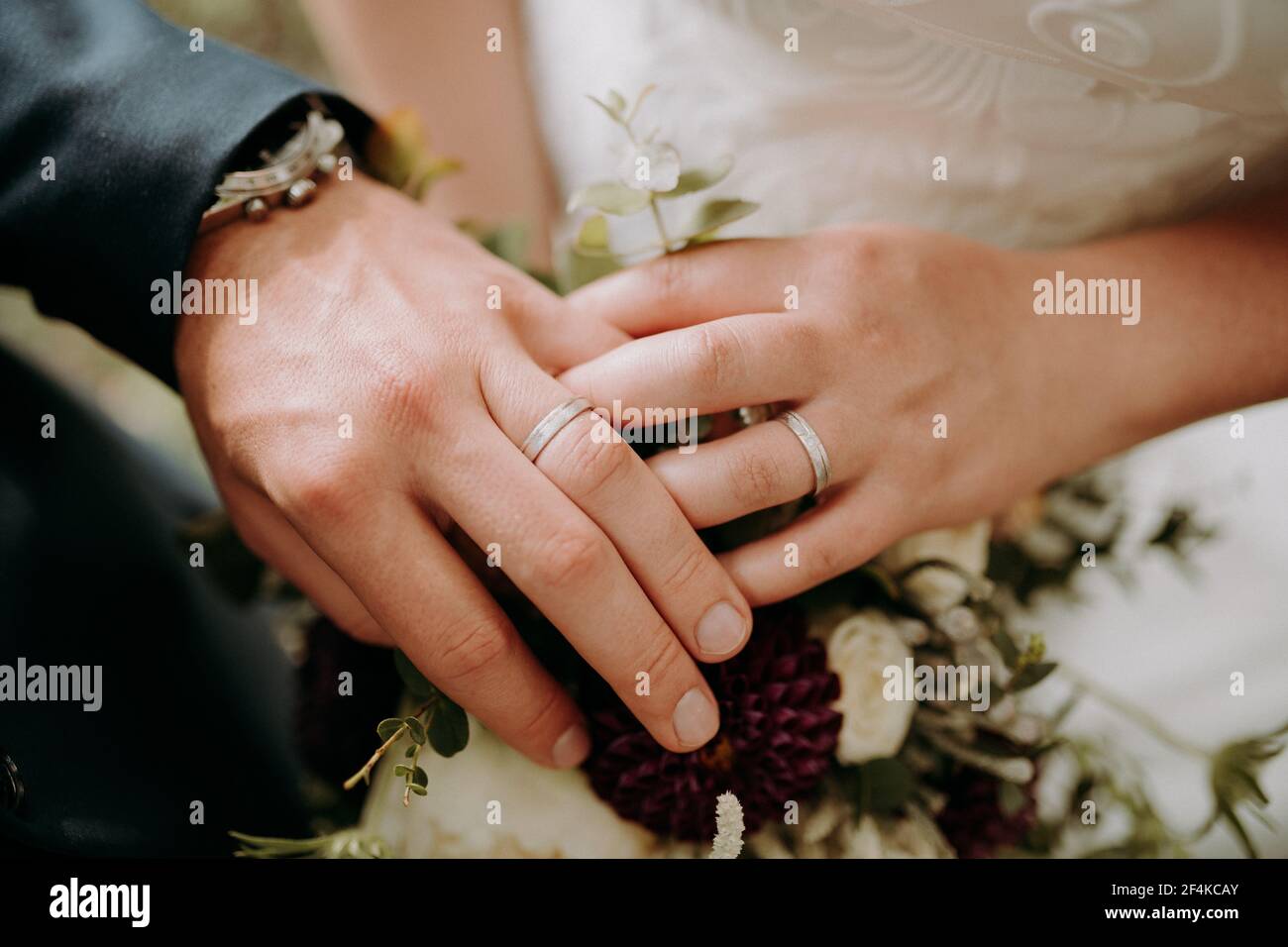 wedding rings on hands with man watches Stock Photo - Alamy