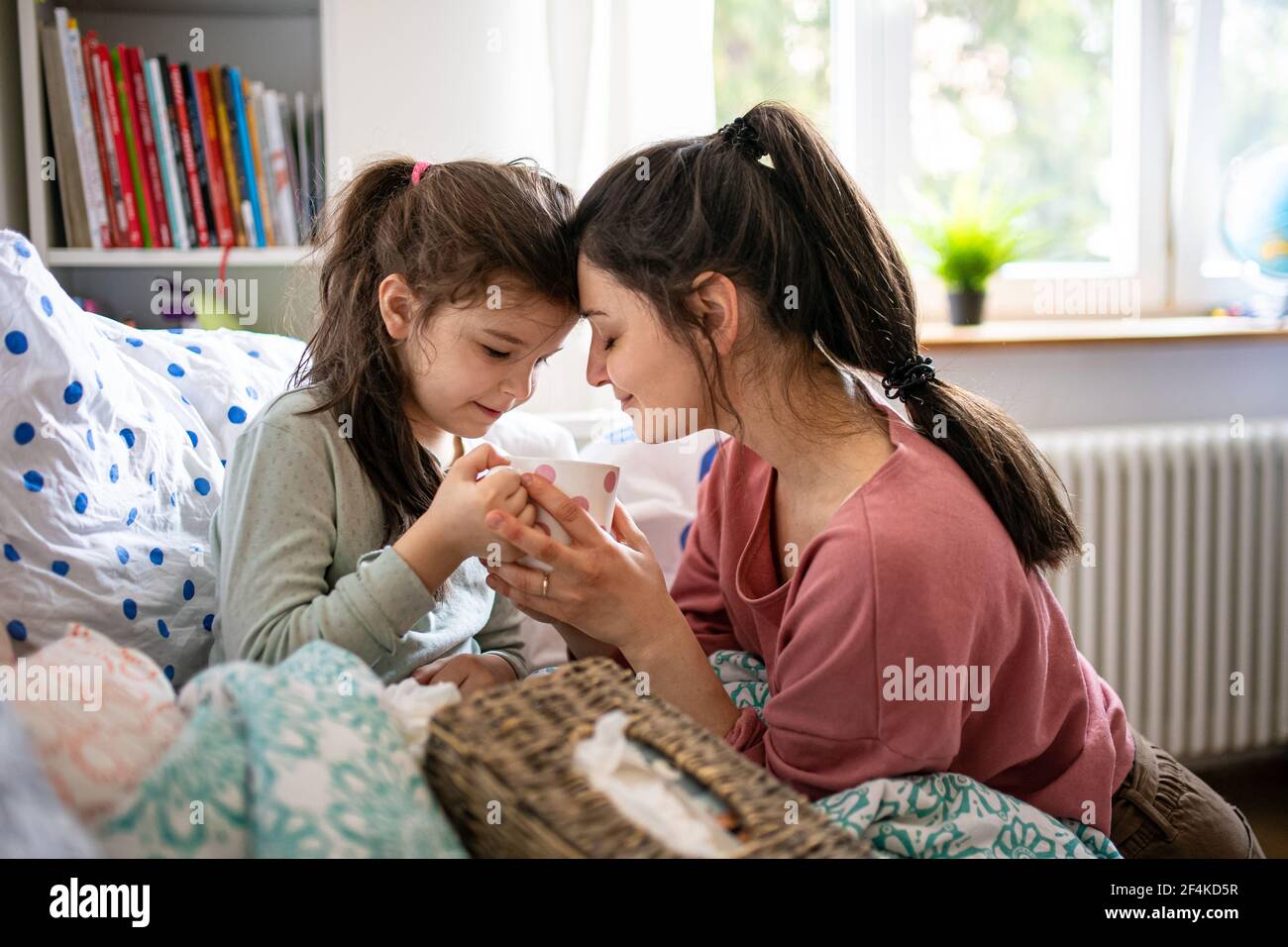 Mother looking after sick small daughter in bed at home Stock Photo - Alamy