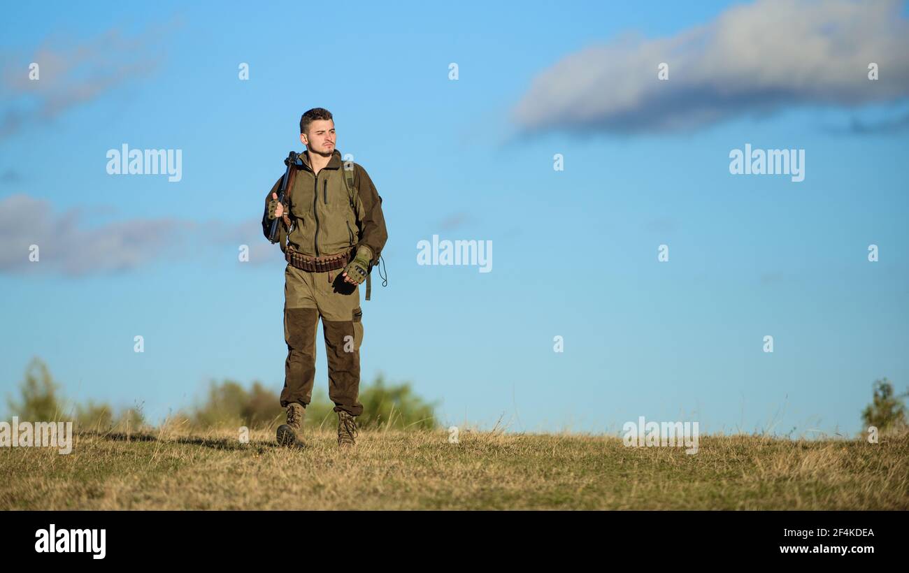 Masculine hobby activity. Man hunter carry rifle blue sky background ...