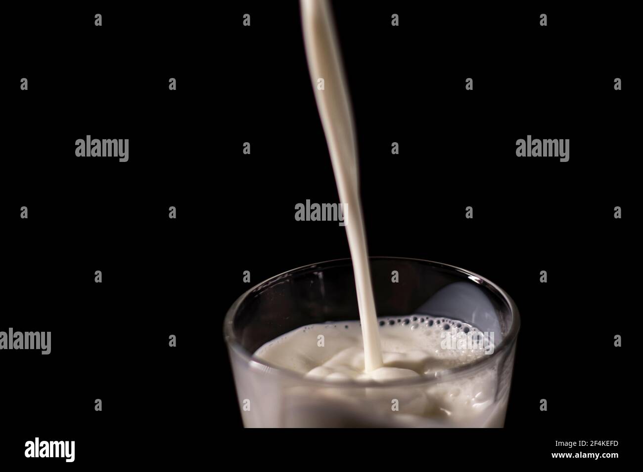 pouring milk in a glass. splash of white liquid isolated on dark ...