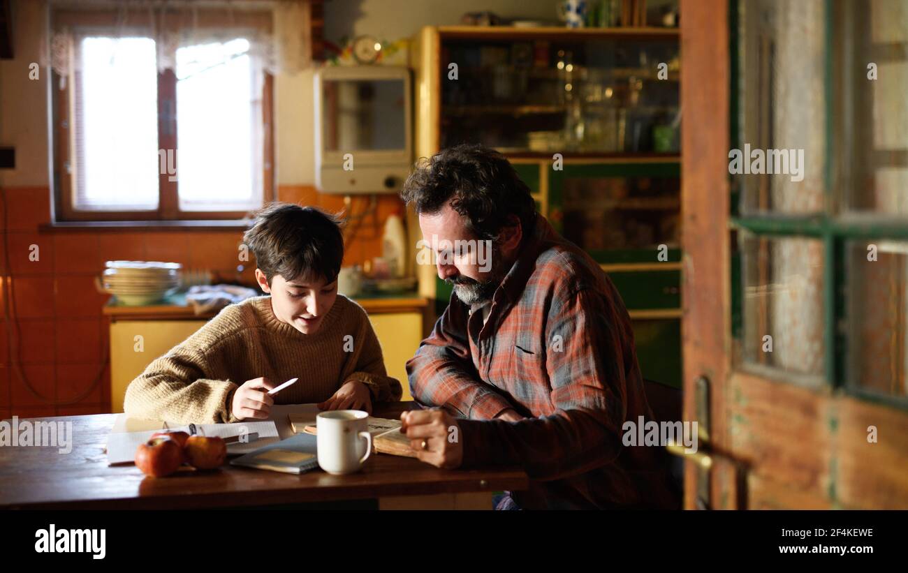 Poor mature father and small daughter learning indoors at home, poverty ...