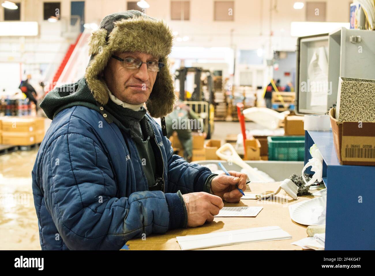 New York City, USA. Wholesale market stall employee crunching the ...