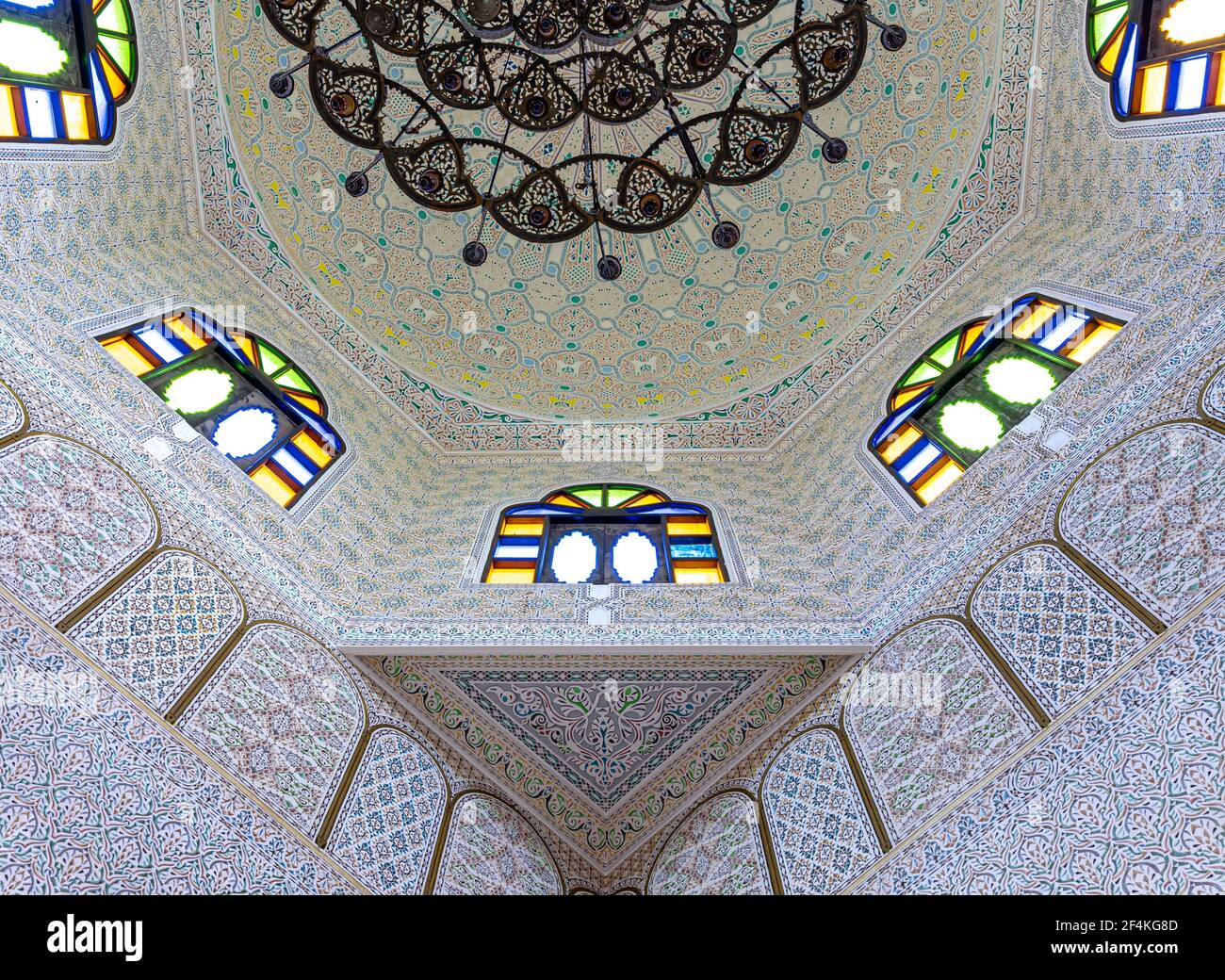 Bottom view of ceiling with stained glass windows and many ornaments ...
