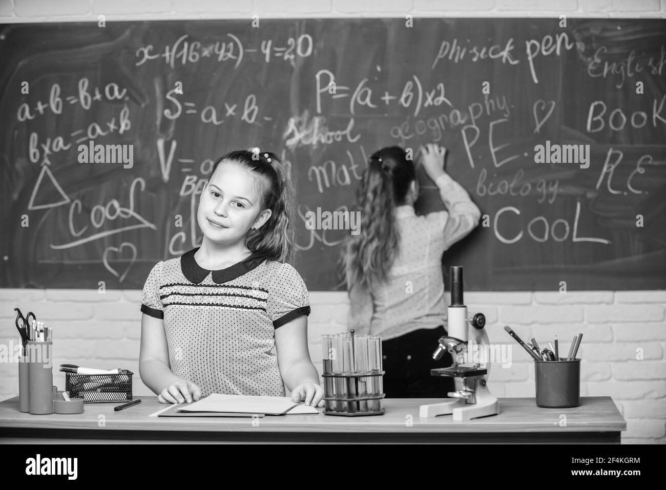 Using modern technologies. Little girls scientist work with microscope ...