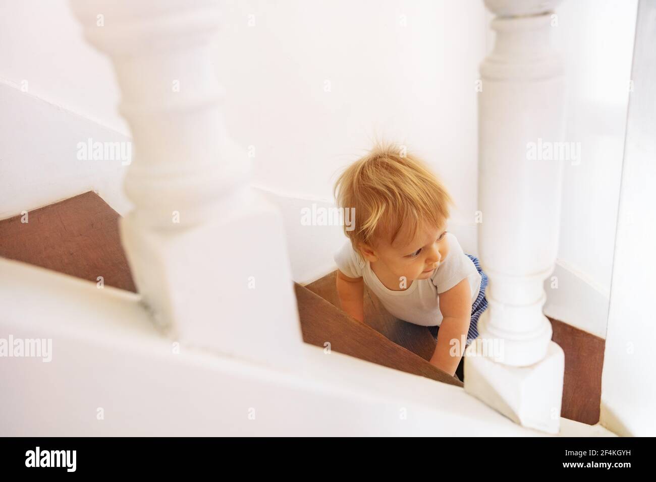 Little puzzled boy climbing stairs looking back Stock Photo - Alamy