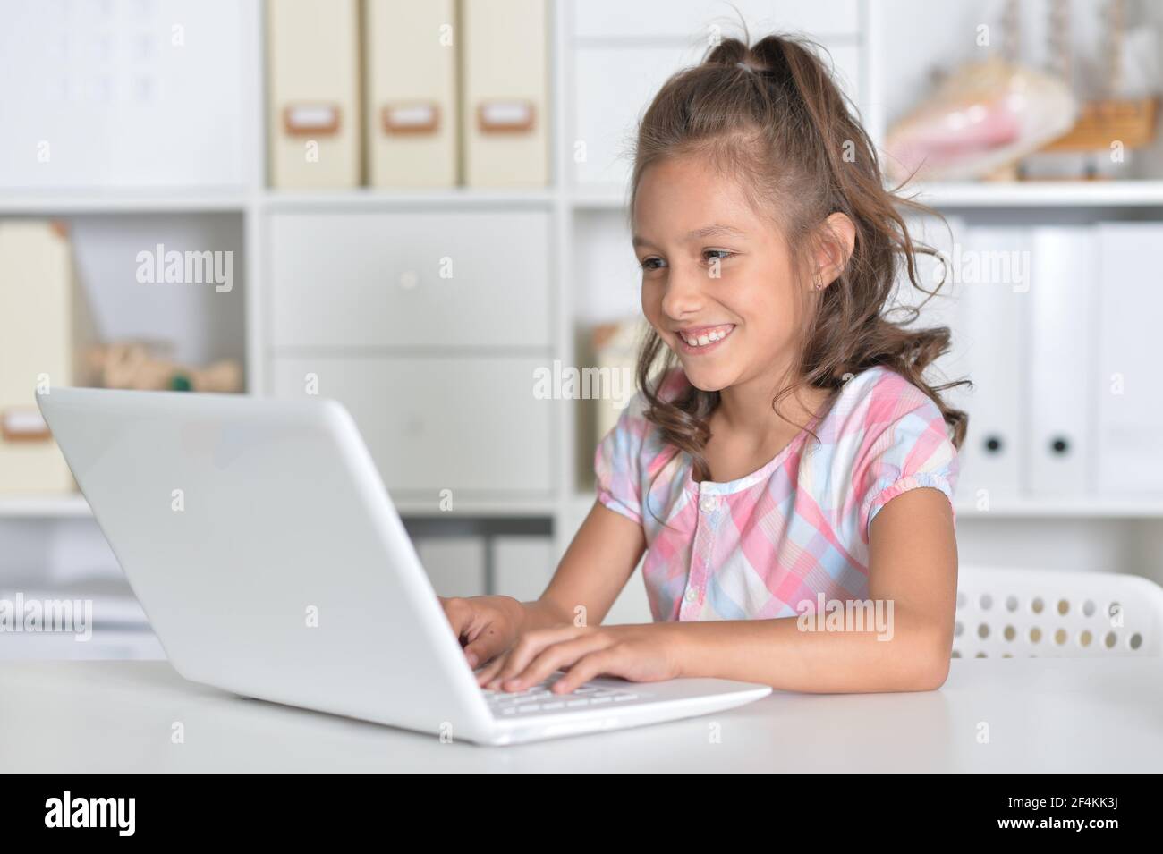 Portrait of emotional cute girl using laptop Stock Photo - Alamy