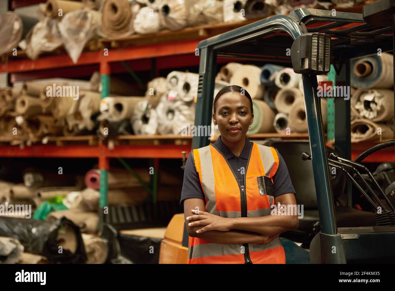 African female forklift operator standing in a textile storehouse Stock ...