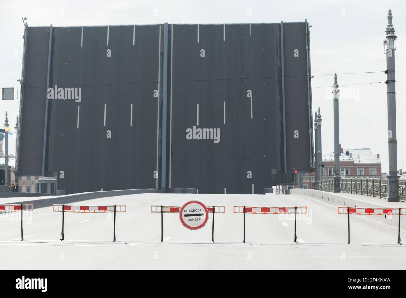 Warning road signs stand near a raised span of a drawbridge ...