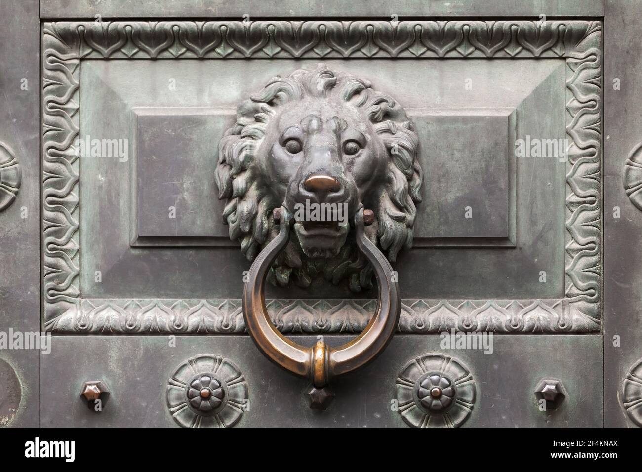 Old classic knocker in shape of lion head with ring mounted on dark ...