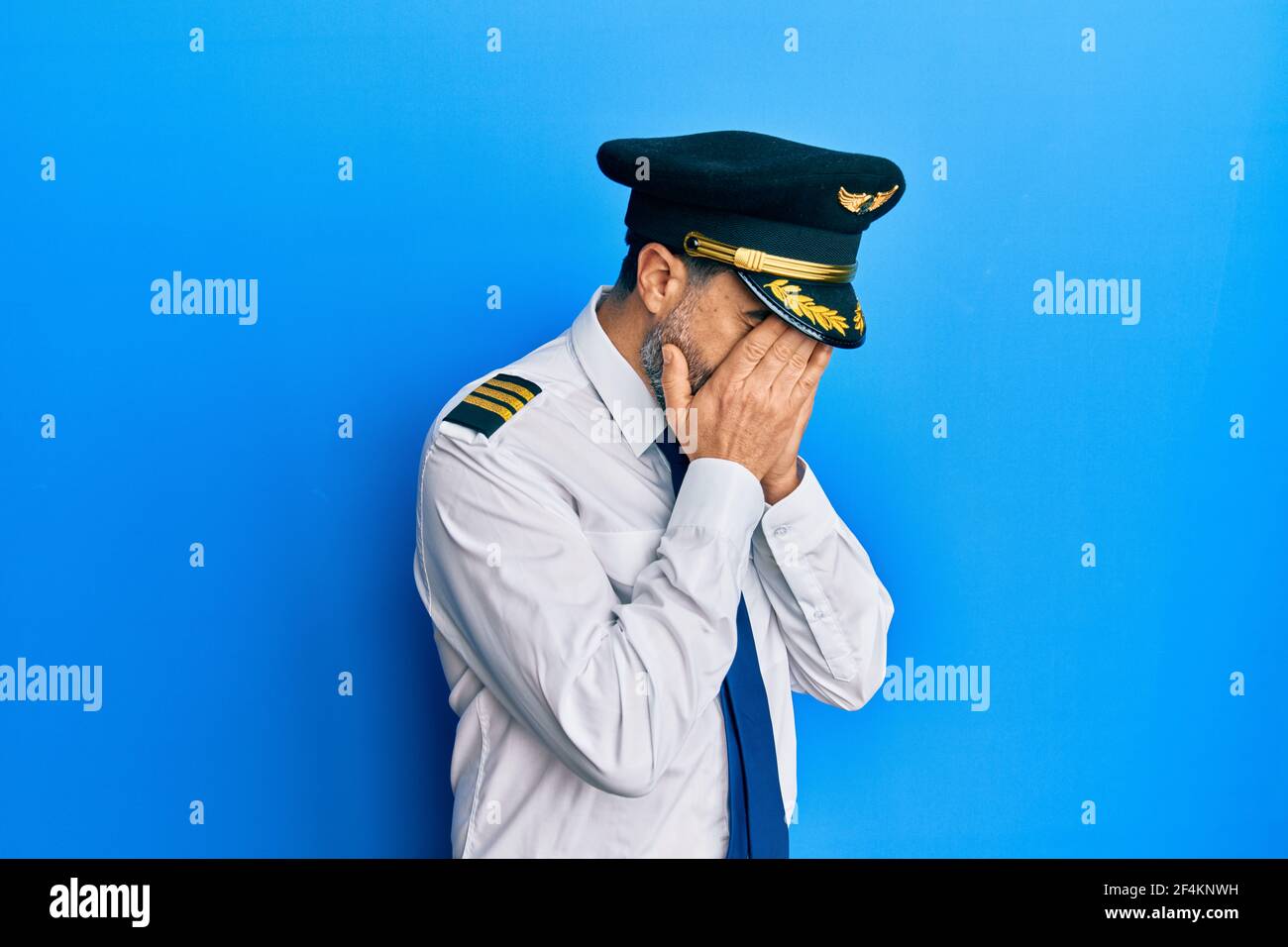 Middle age man with beard and grey hair wearing airplane pilot uniform ...