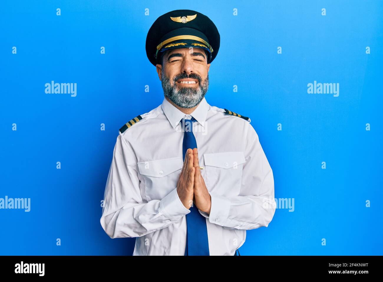 Middle age man with beard and grey hair wearing airplane pilot uniform ...