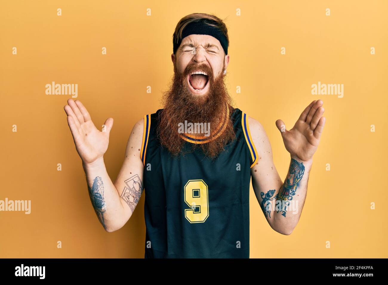 Redhead man with long beard wearing basketball uniform celebrating mad ...