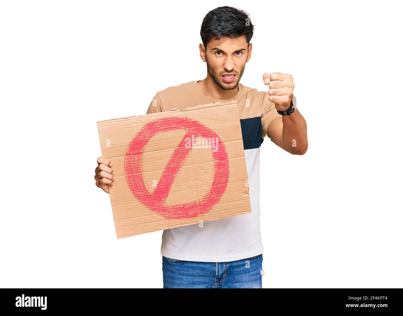 Young handsome man holding prohibited warning banner annoyed and ...