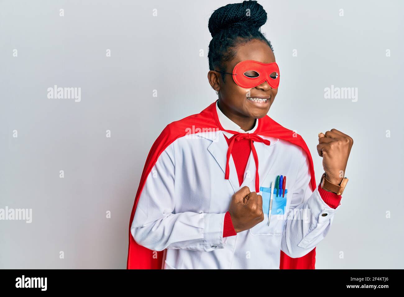 Young african american woman wearing doctor uniform and super hero ...