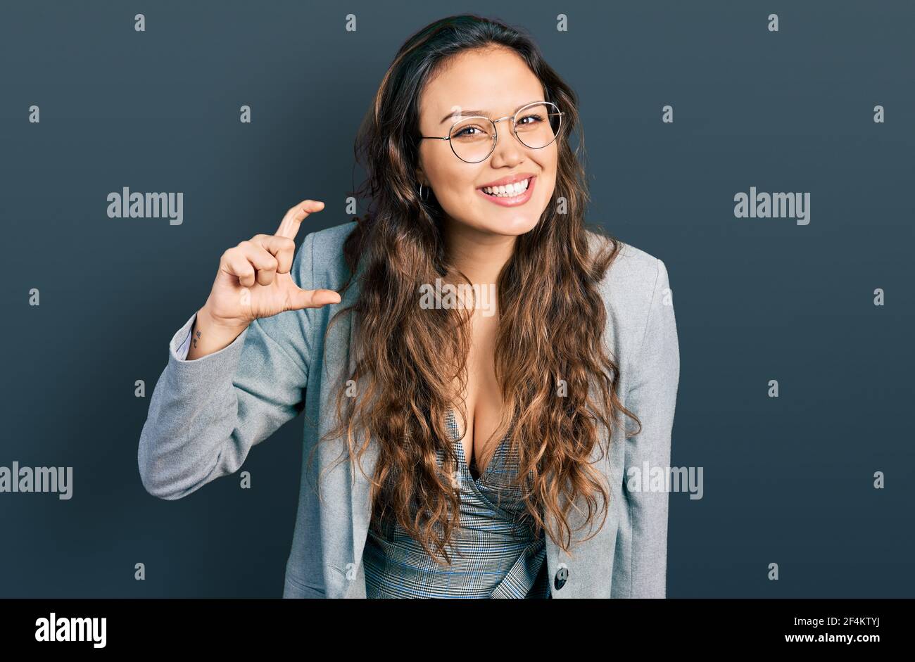 Young hispanic girl wearing business clothes and glasses smiling and ...