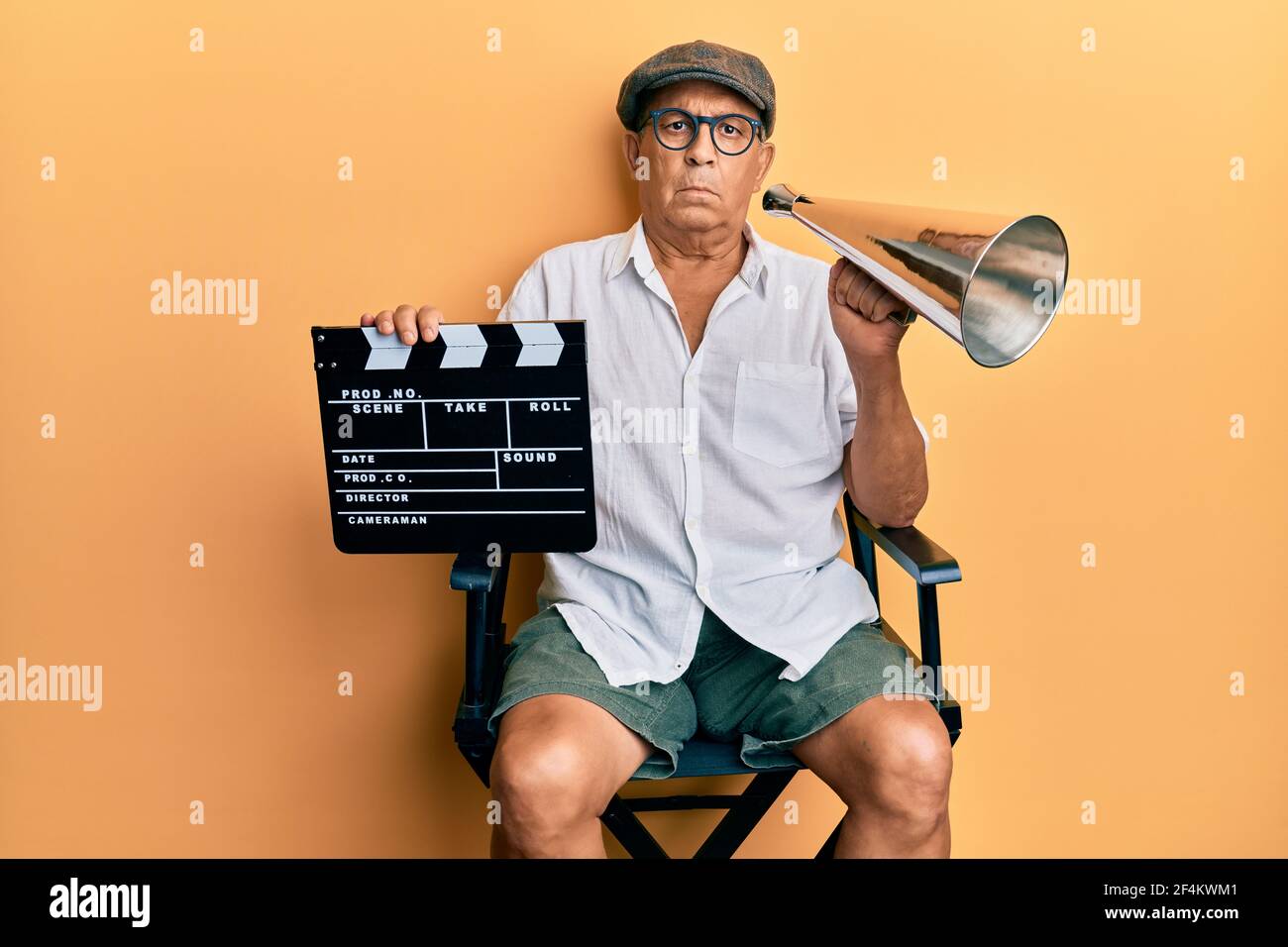 Handsome mature director man holding video film clapboard and louder ...