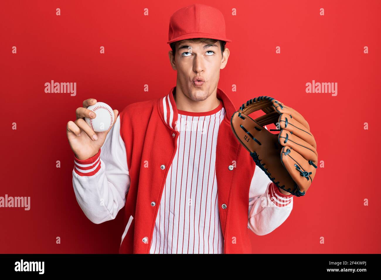 Handsome caucasian man wearing baseball uniform holding golve and ball ...