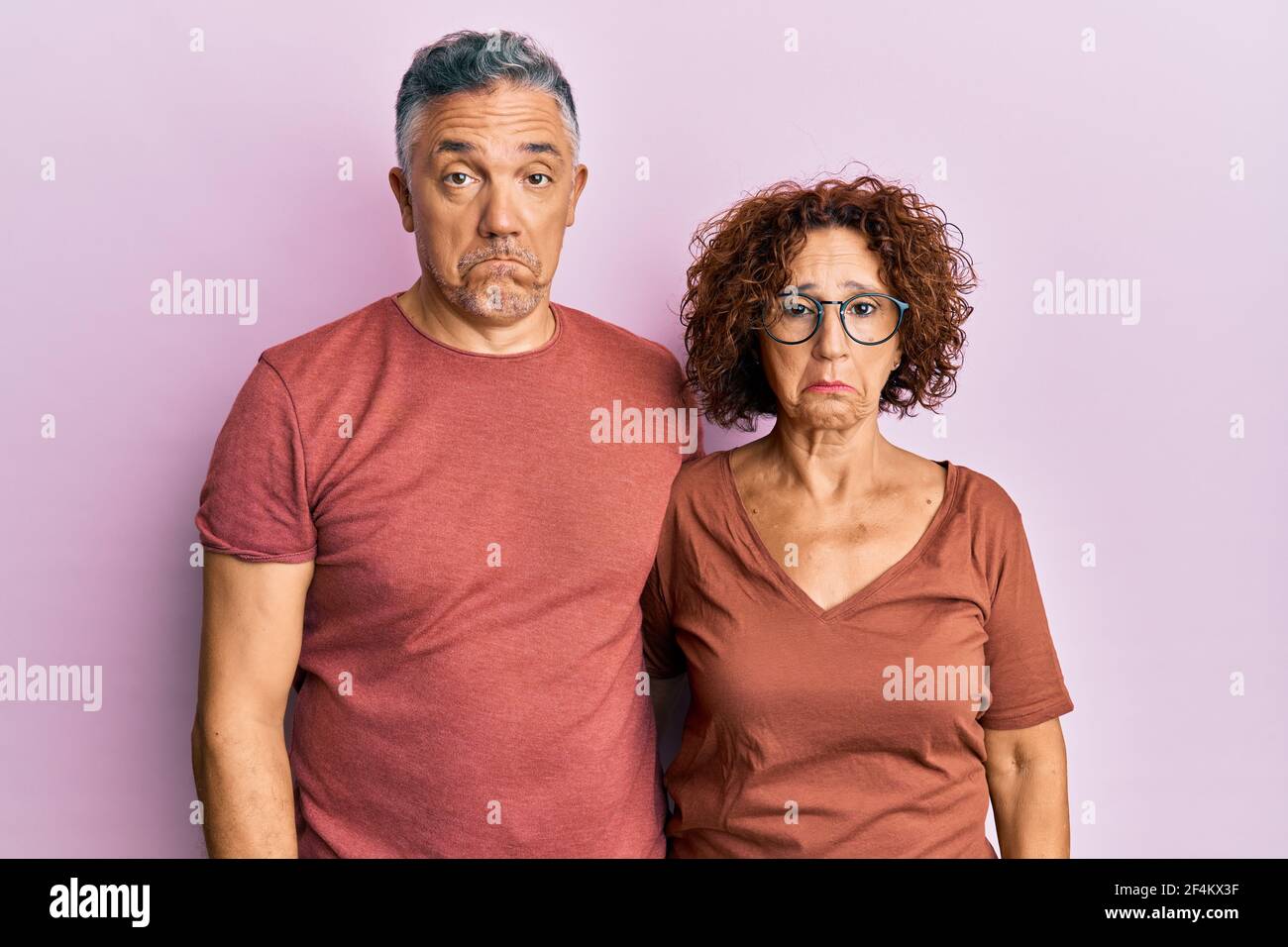 Beautiful middle age couple together wearing casual clothes depressed ...