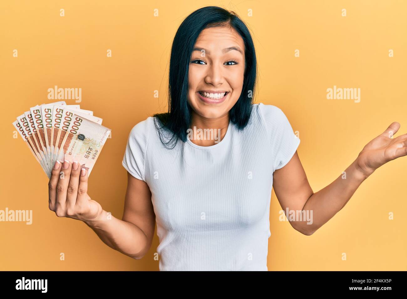 Beautiful hispanic woman holding 5000 south korean won banknotes ...