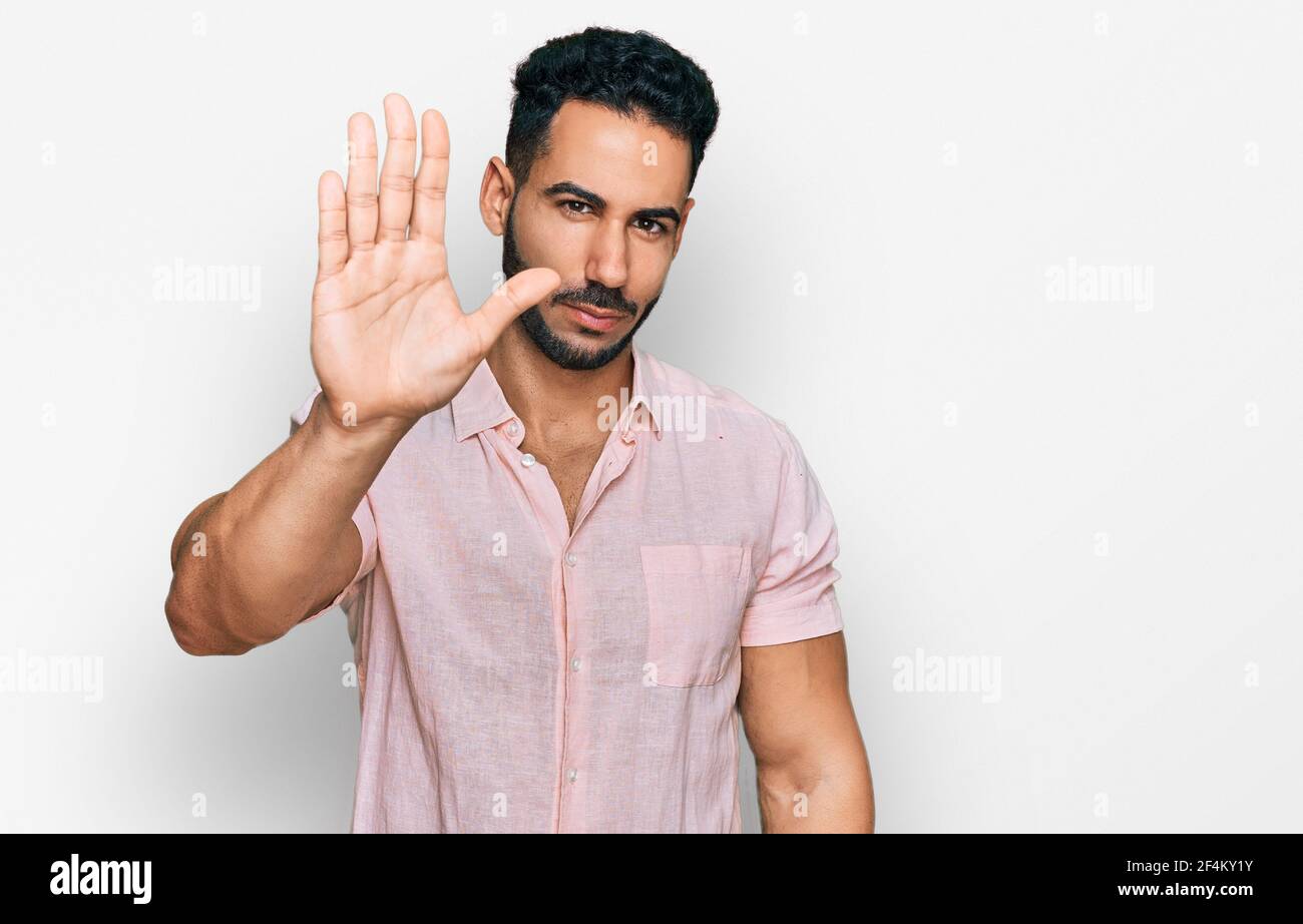 Hispanic man with beard wearing casual shirt doing stop sing with palm ...