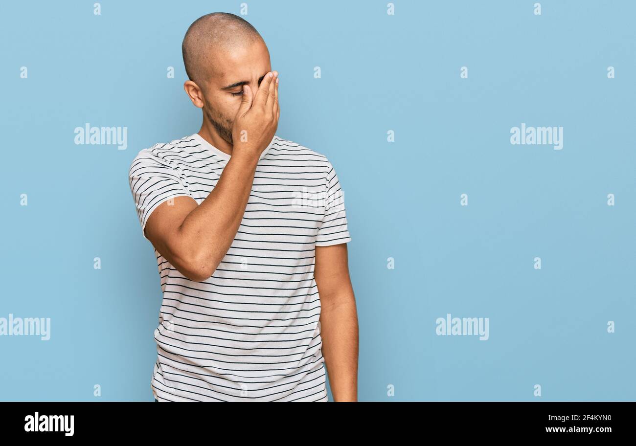 Hispanic adult man wearing casual clothes tired rubbing nose and eyes ...