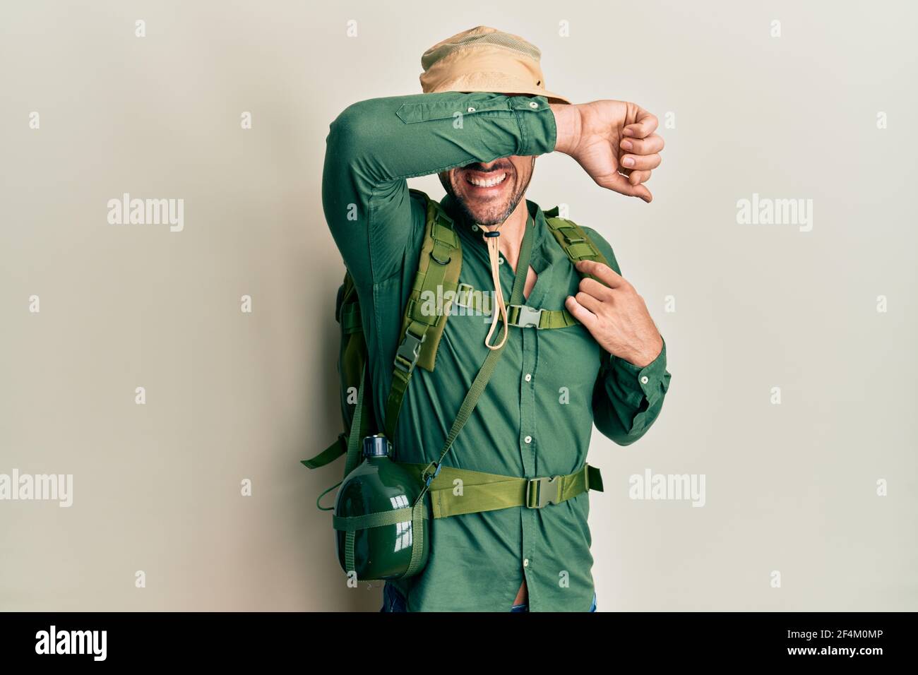 Handsome man with beard wearing explorer hat and backpack smiling ...