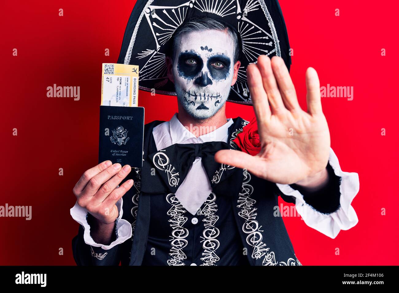 Young man wearing mexican day of the dead costume holding united states ...