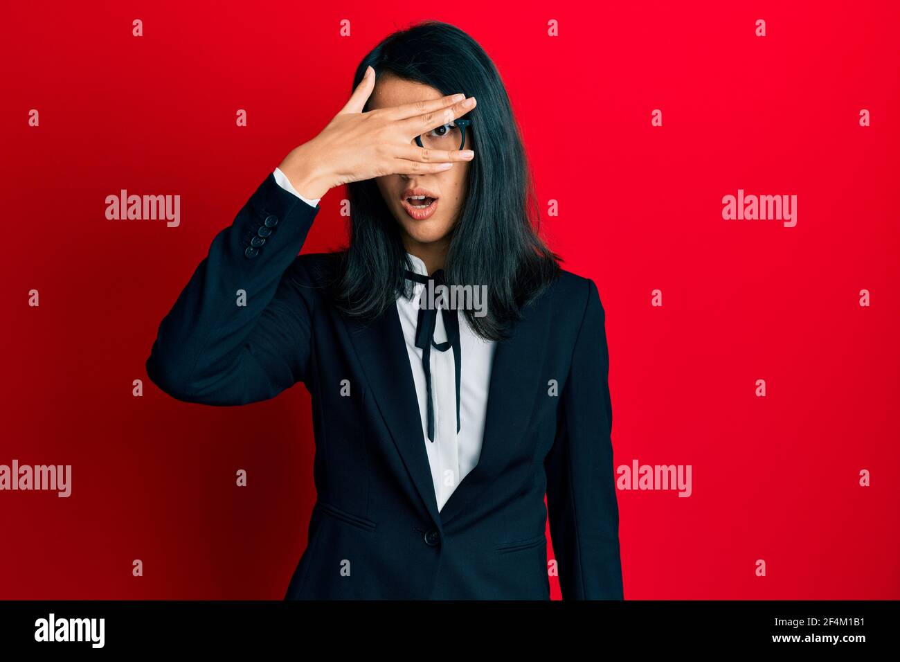 Beautiful asian young woman wearing business suit peeking in shock ...