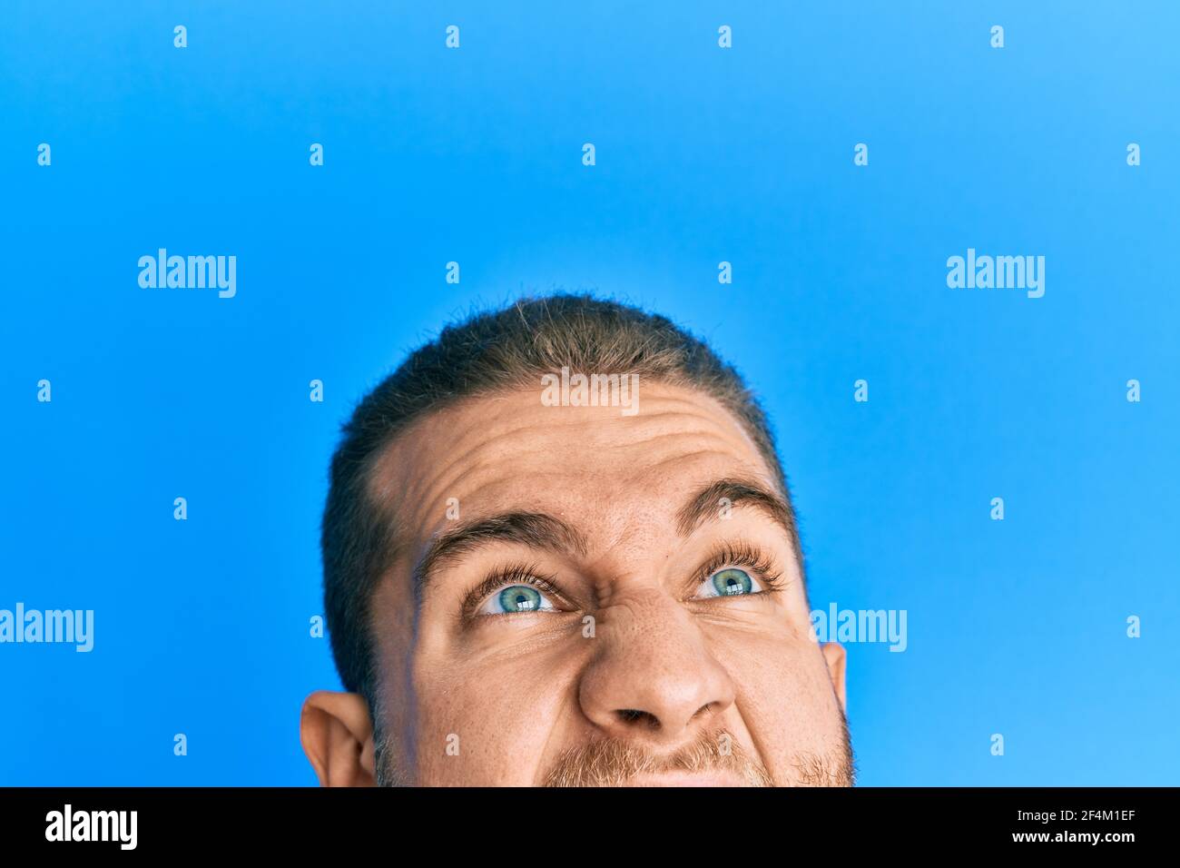 Young caucasian man showing head and half face angry and mad screaming ...