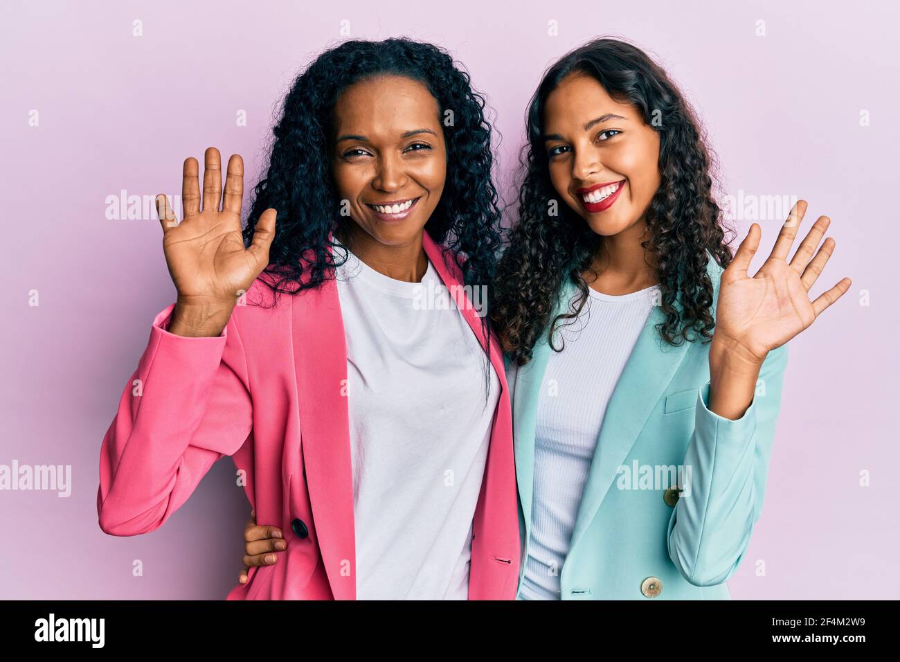 African american mother and daughter wearing business style waiving ...