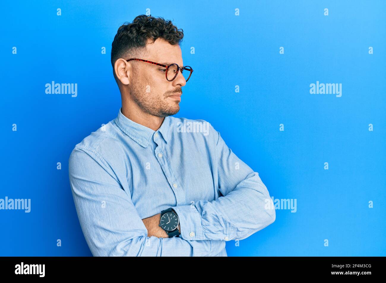 Young hispanic man wearing casual clothes and glasses looking to the ...