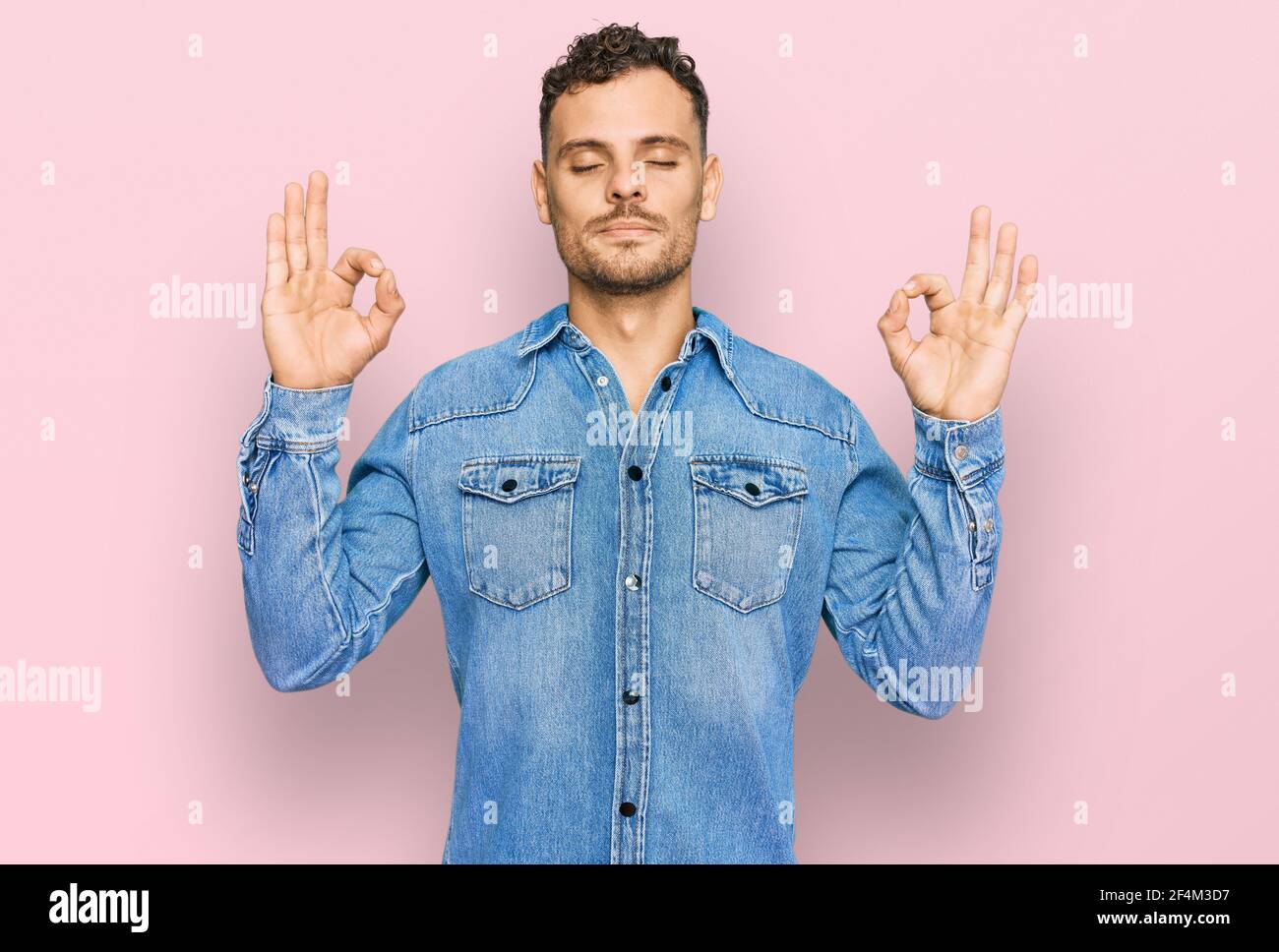 Young hispanic man wearing casual denim jacket relax and smiling with ...