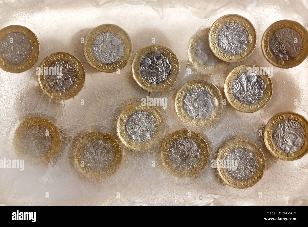 Photograph of £1 coins set in a block of ice Stock Photo - Alamy