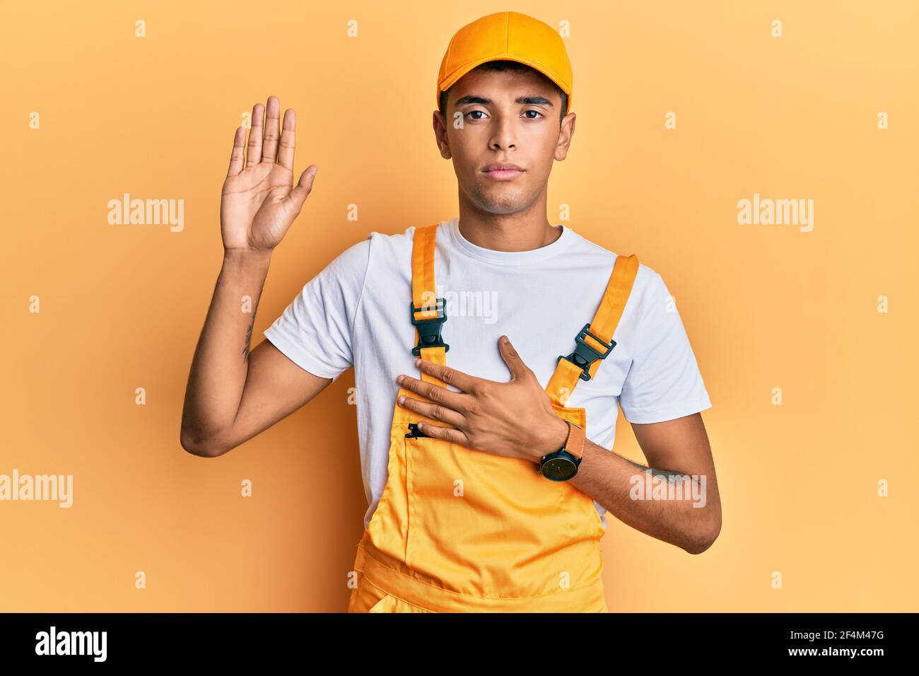 Young handsome african american man wearing handyman uniform over ...